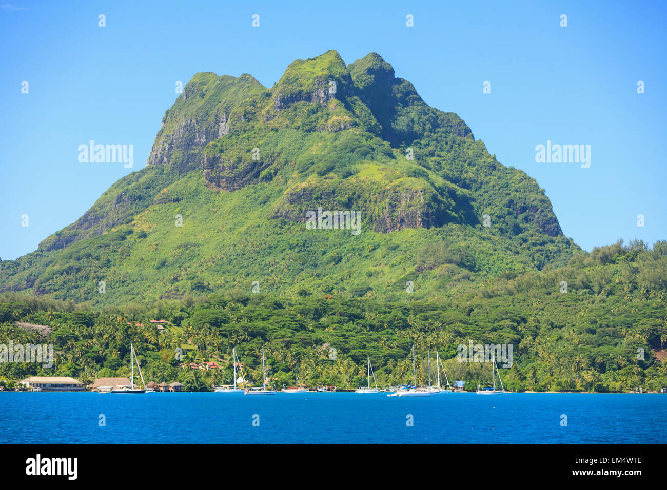 A Large Rock Formation Against A Blue Sky Along The Coast; Bora Bora ...
