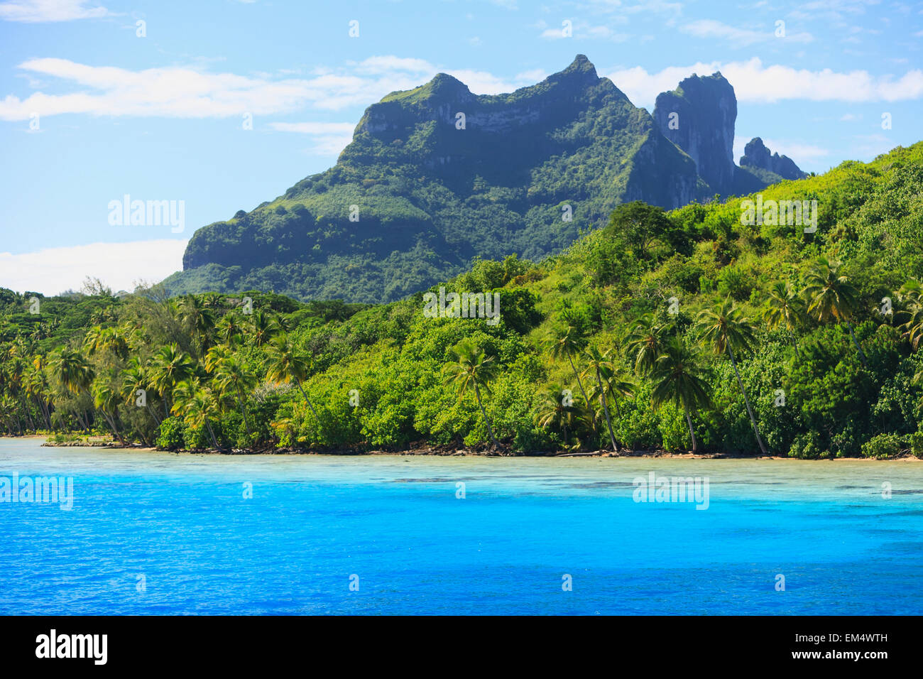 A Large Rock Formation Against A Blue Sky Along The Coast; Bora Bora ...