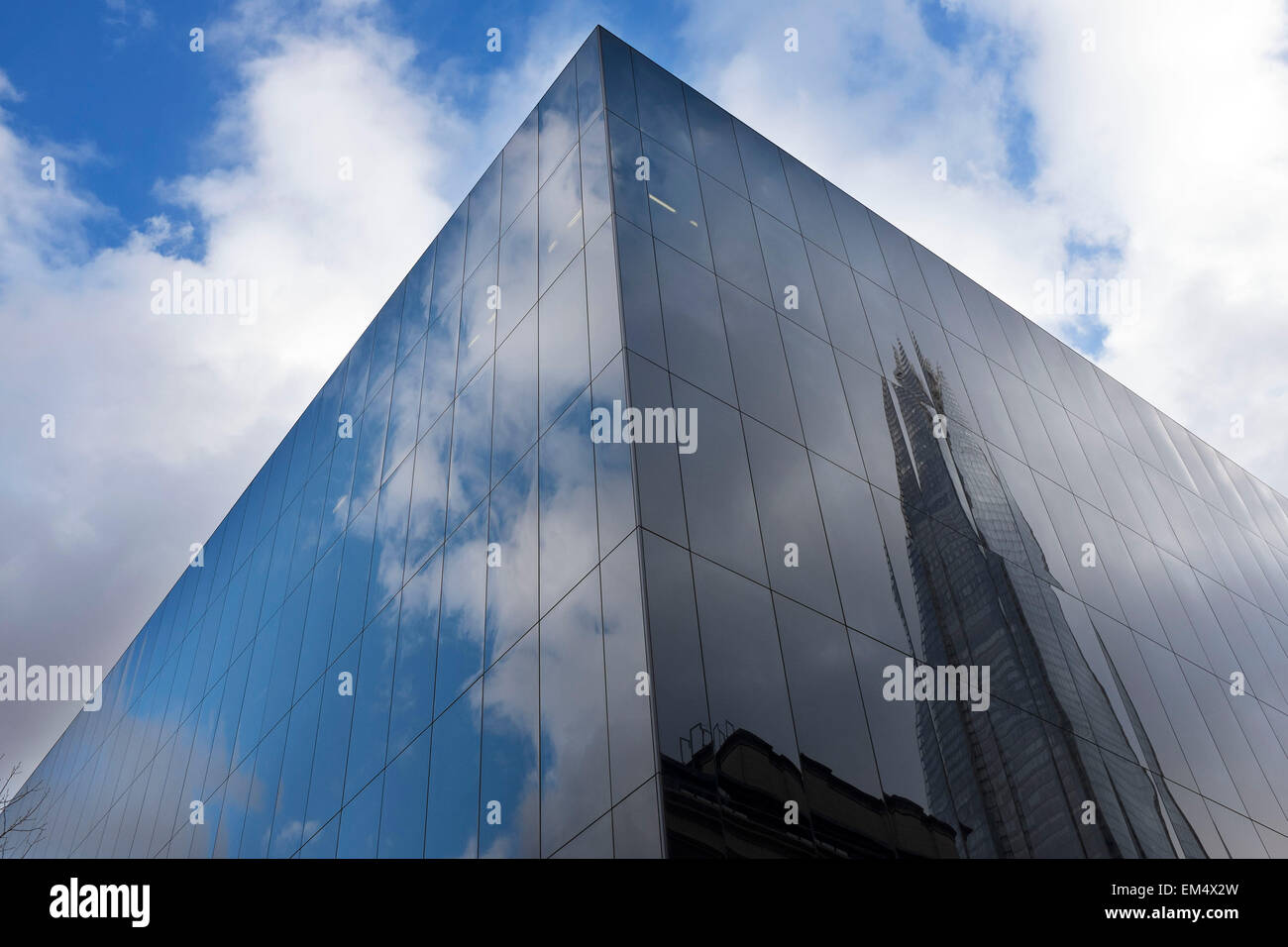 Glass building reflecting the clouds and The Shard in a blue sky ...
