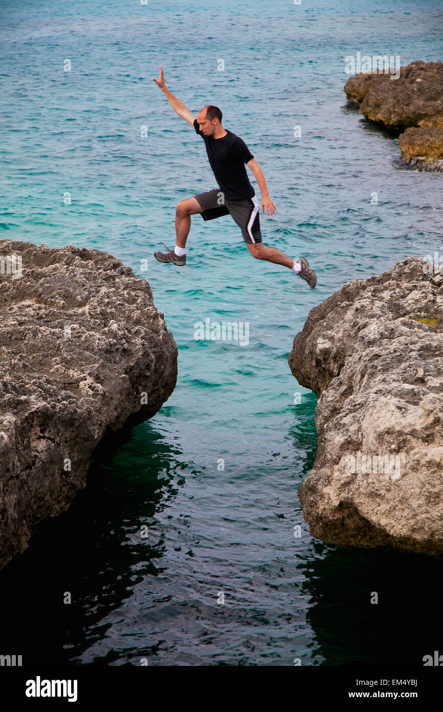 Aruba, Orangestad, Man jumping rocks on tropical sea Stock Photo - Alamy