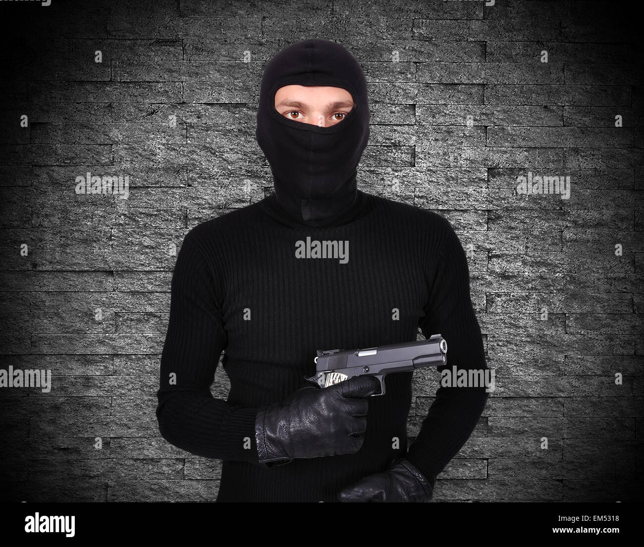 killer with gun on black wall background Stock Photo - Alamy