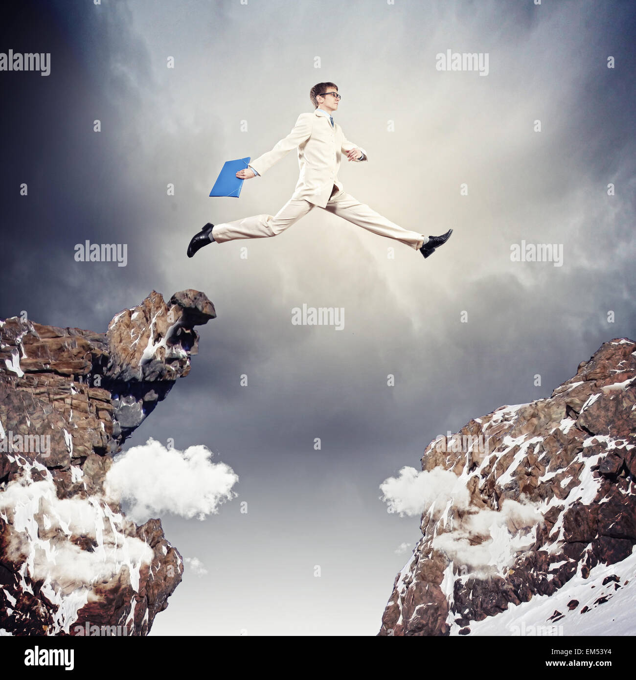Businessman jumping over gap Stock Photo - Alamy
