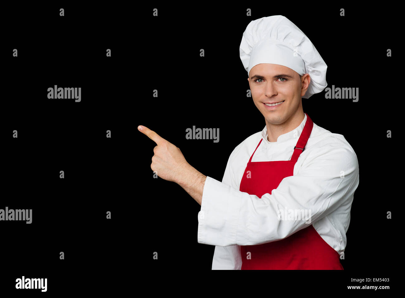 Young chef pointing towards something Stock Photo - Alamy