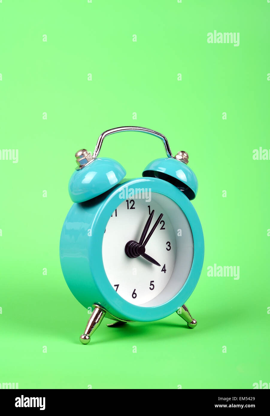 old style alarm clock on green background Stock Photo - Alamy