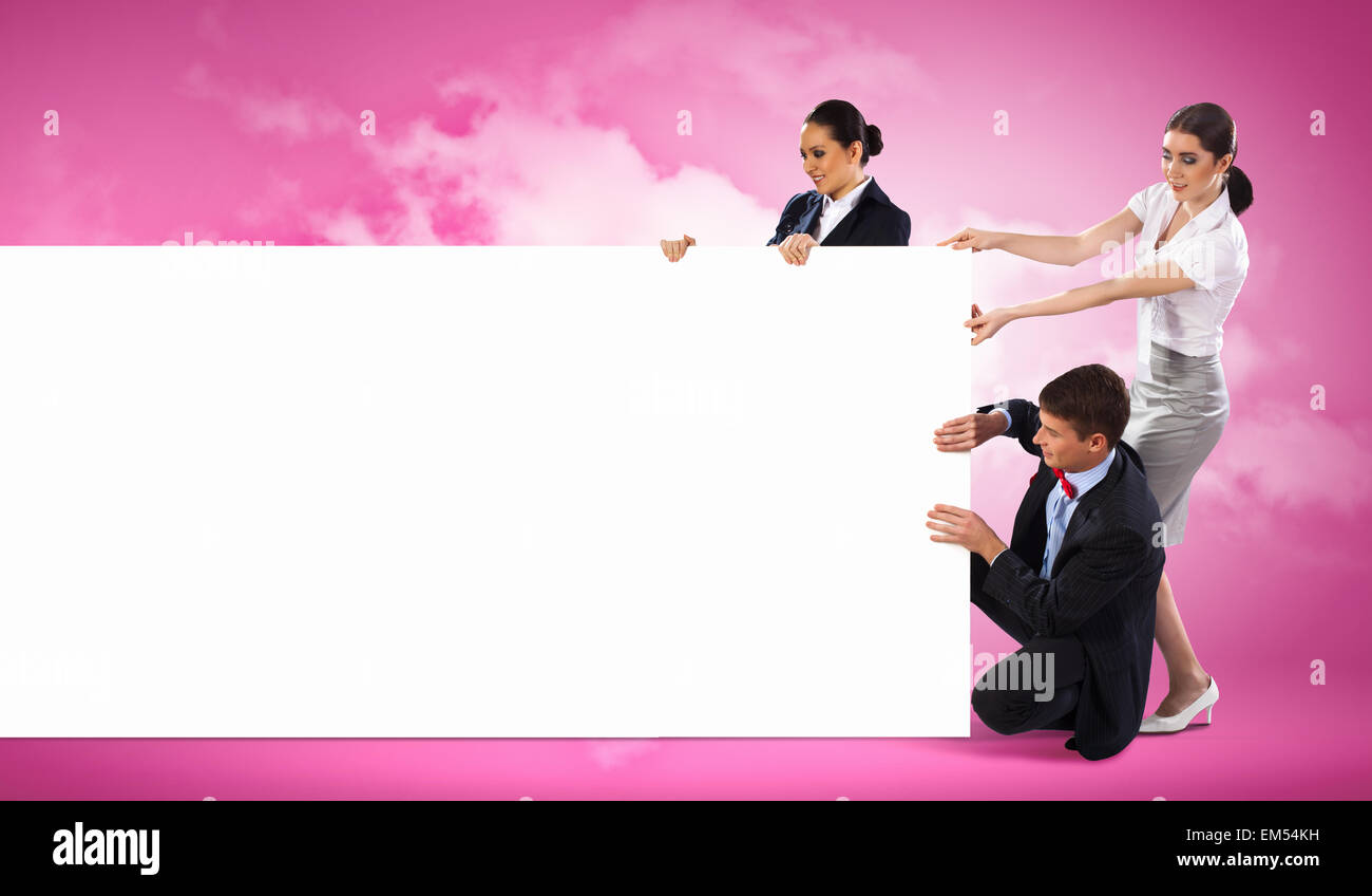 Three young people holding banner Stock Photo - Alamy