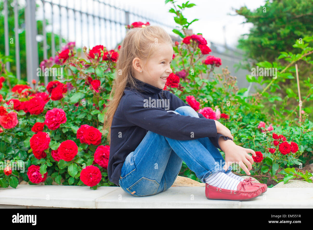 Cute little girl near the flowers in yard of her house Stock Photo - Alamy