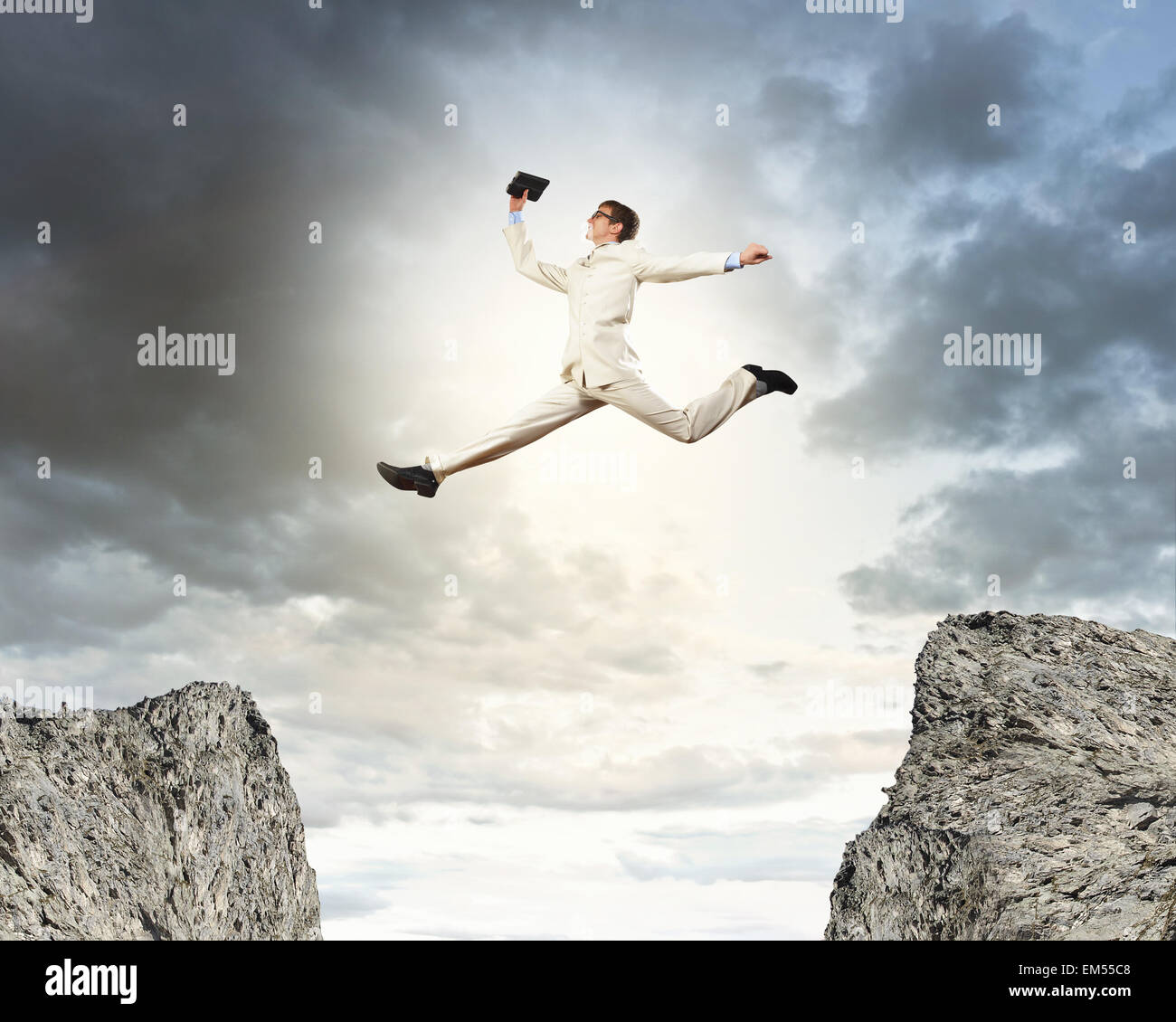 Businessman jumping over gap Stock Photo - Alamy
