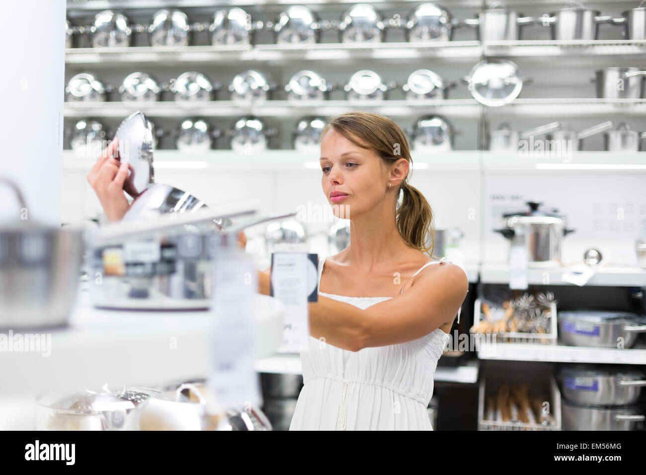 Pretty, young woman choosing a the right pot Stock Photo - Alamy