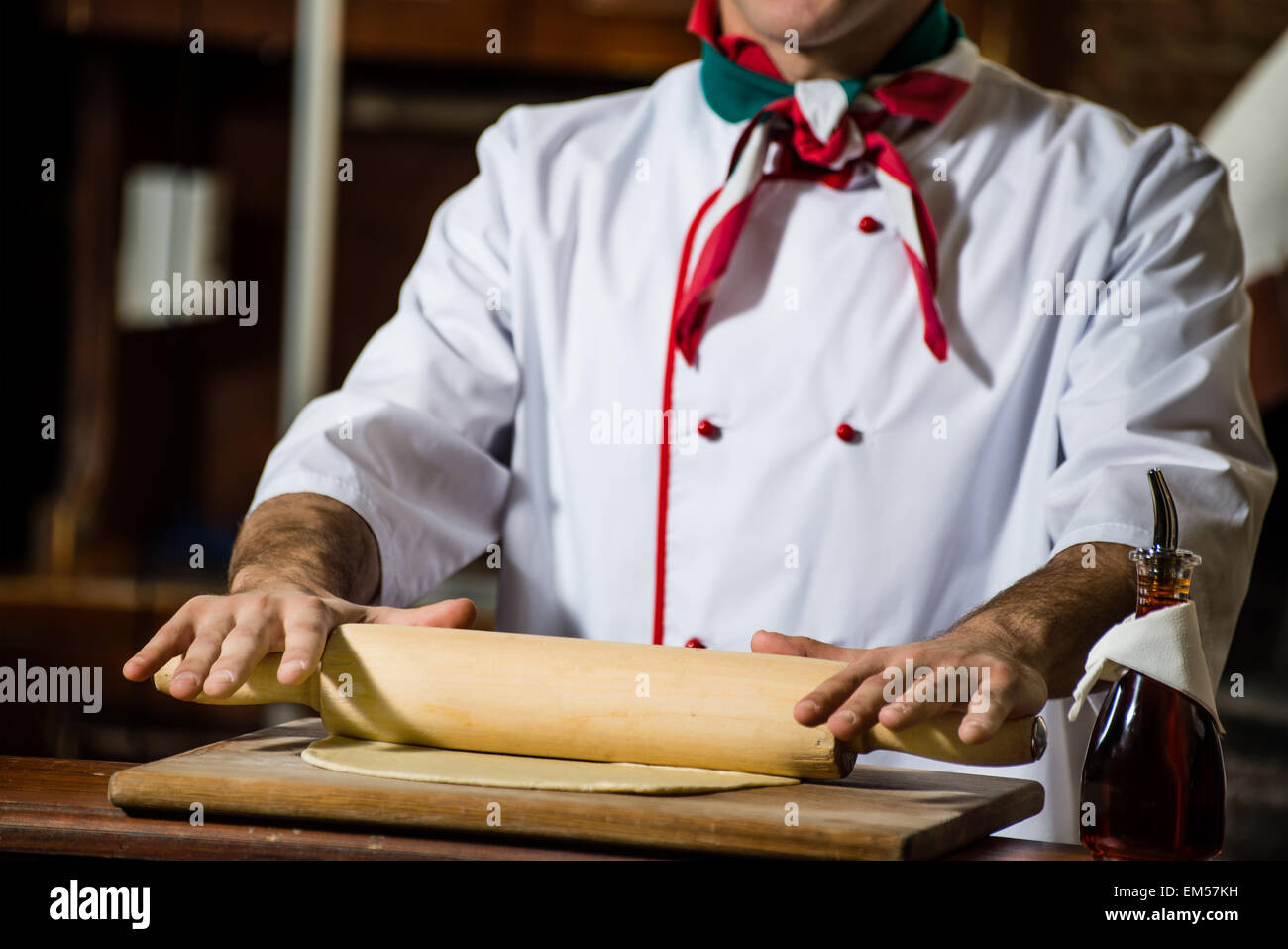 Cook rolls out the dough on a board, the traditional cooking Stock ...