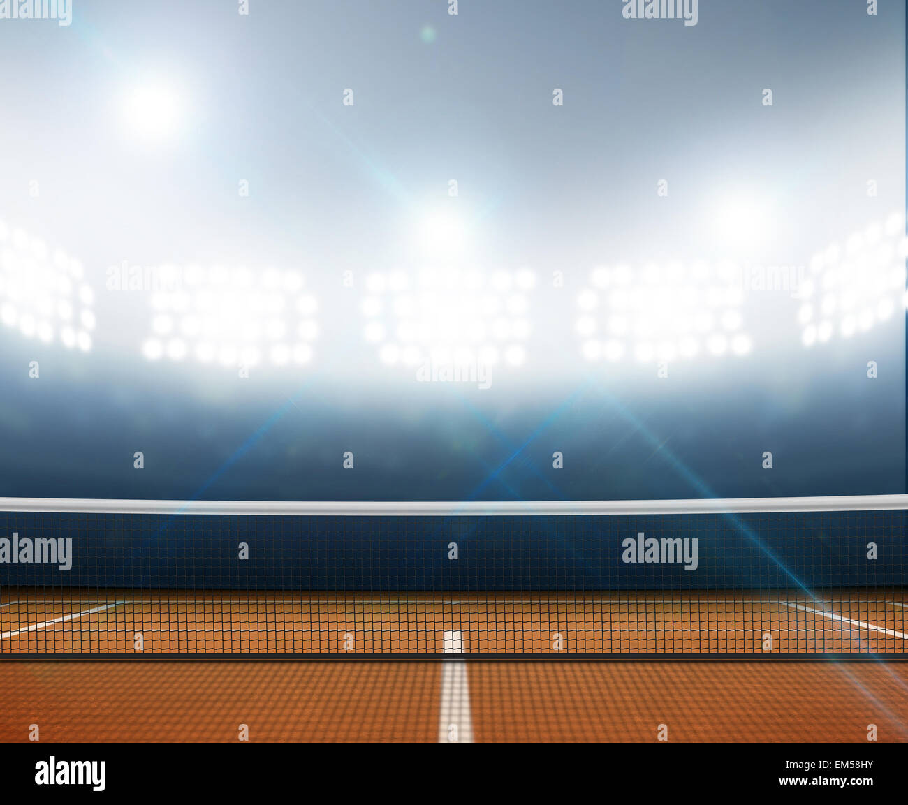 A tennis court in an arena with a marked orange clay surface at night ...
