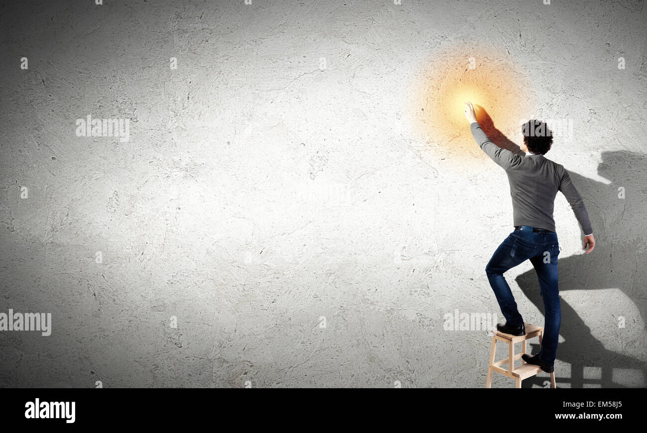 Young man standing near the wall Stock Photo - Alamy
