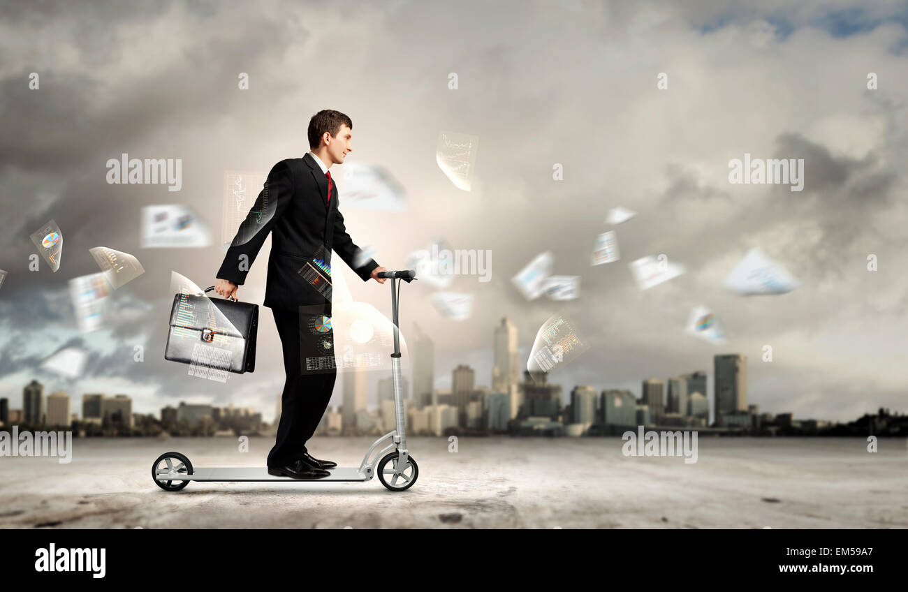 Businessman riding scooter Stock Photo - Alamy