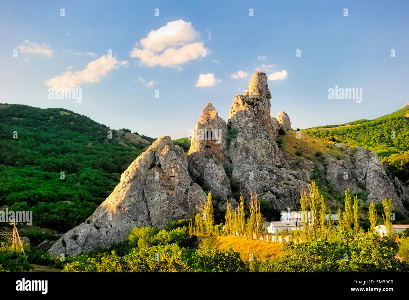 Rock surrounded by green mountains Stock Photo - Alamy