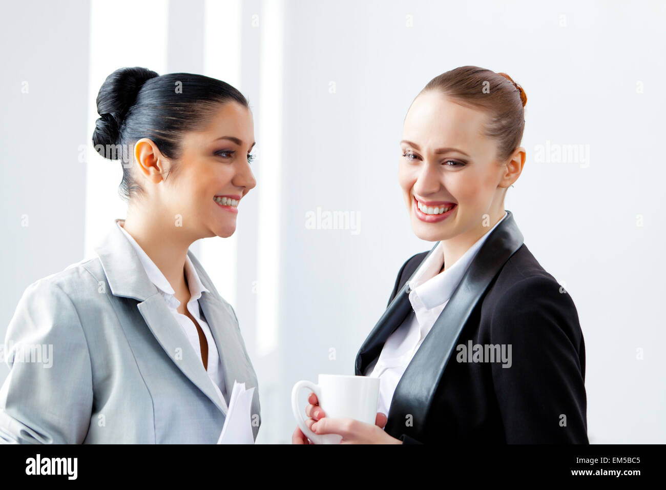 Two attractive business women smiling Stock Photo - Alamy
