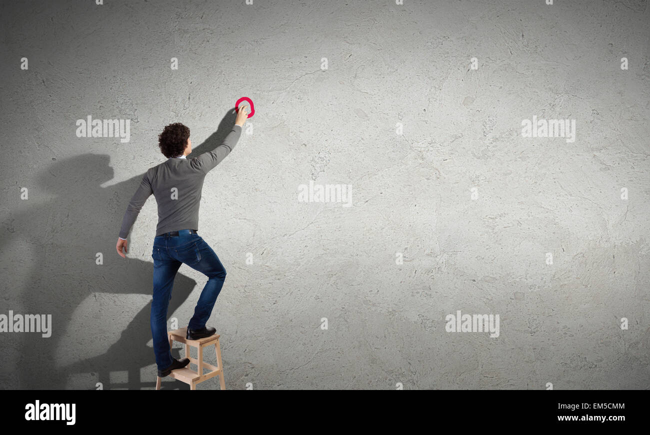 Young man standing near the wall Stock Photo - Alamy