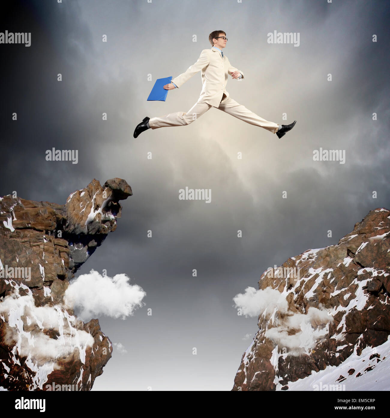 Businessman jumping over gap Stock Photo - Alamy