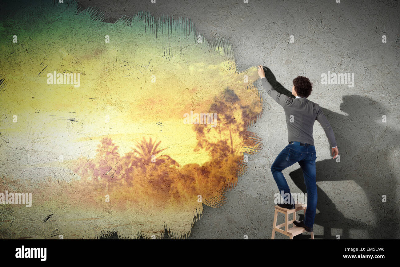 Young man and landscape on the wall Stock Photo - Alamy