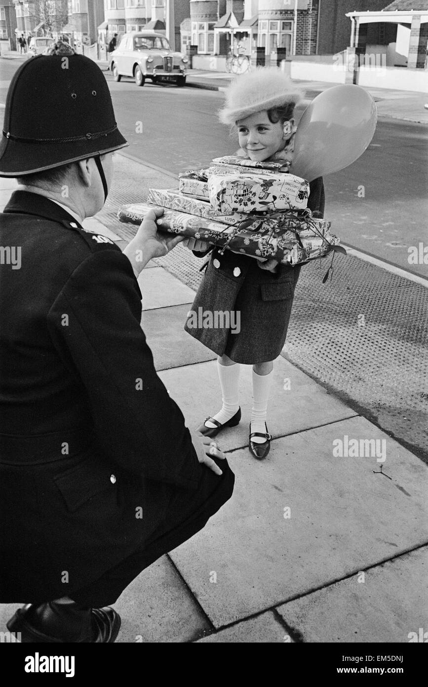 Young Susan Burton holding a pile pf Christmas presents and balloon ...