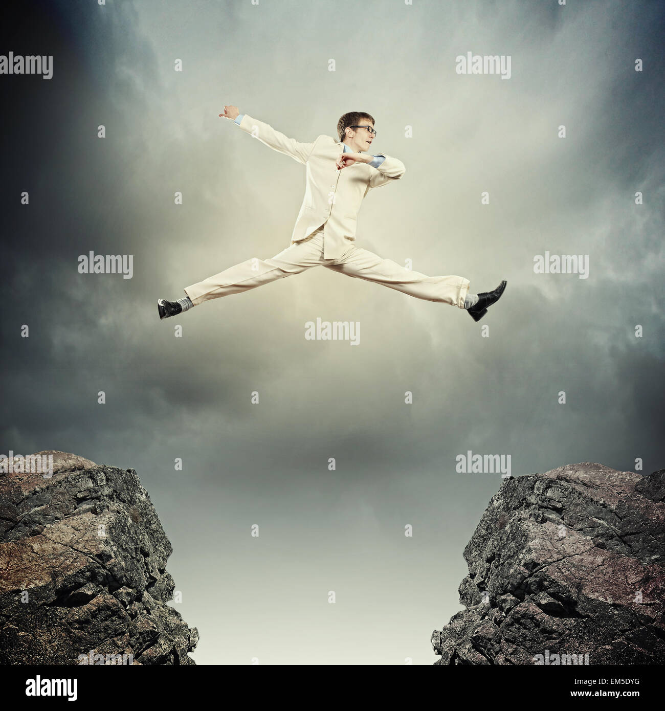 Businessman jumping over gap Stock Photo - Alamy