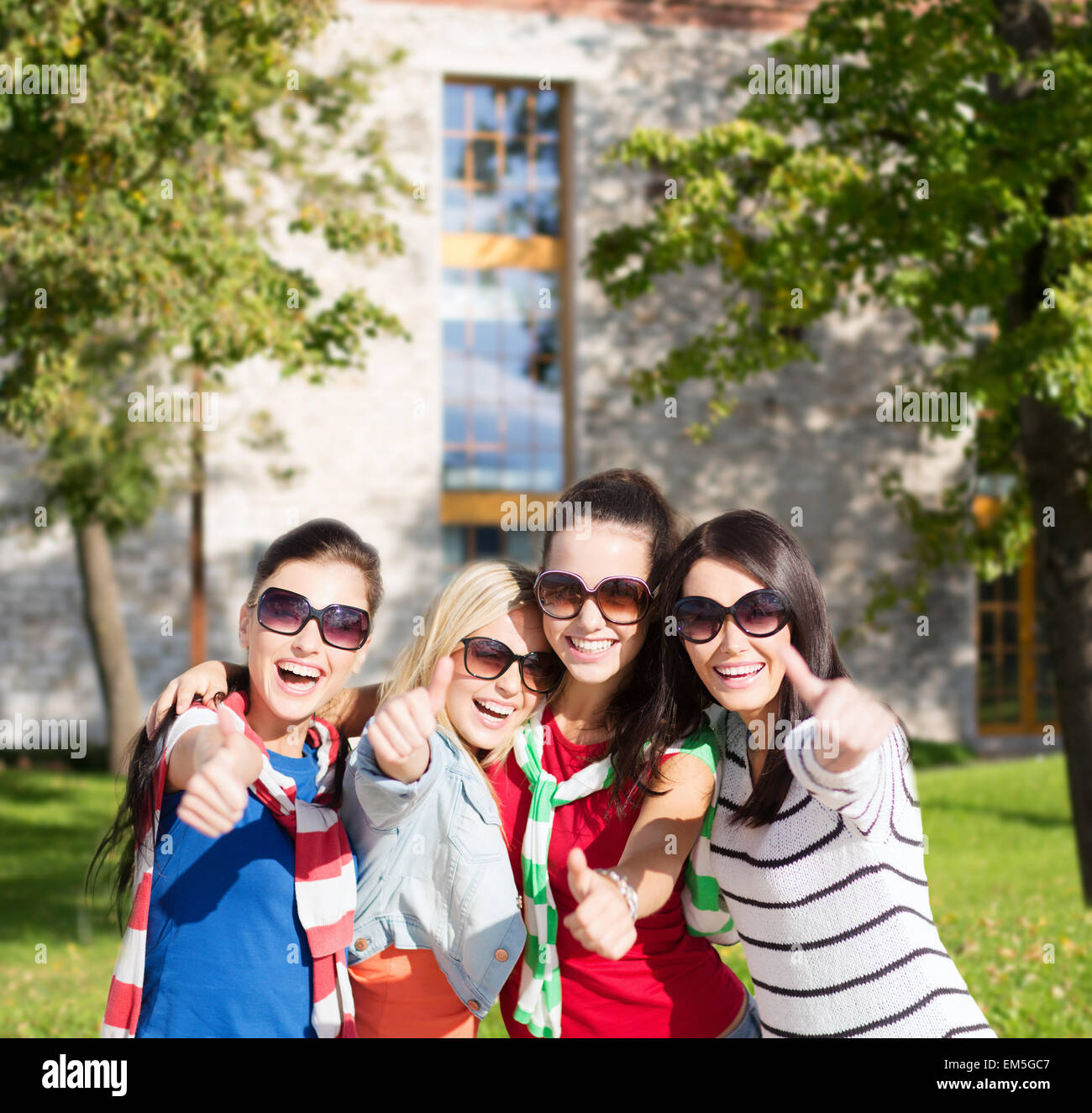 teenage girls or young women showing thumbs up Stock Photo - Alamy