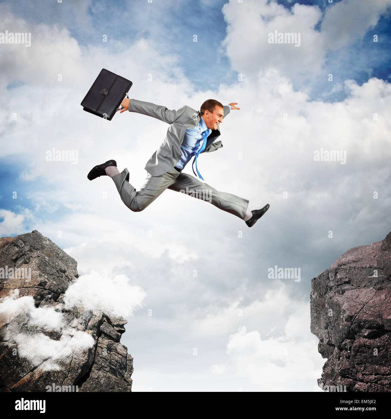 Businessman jumping over gap Stock Photo - Alamy