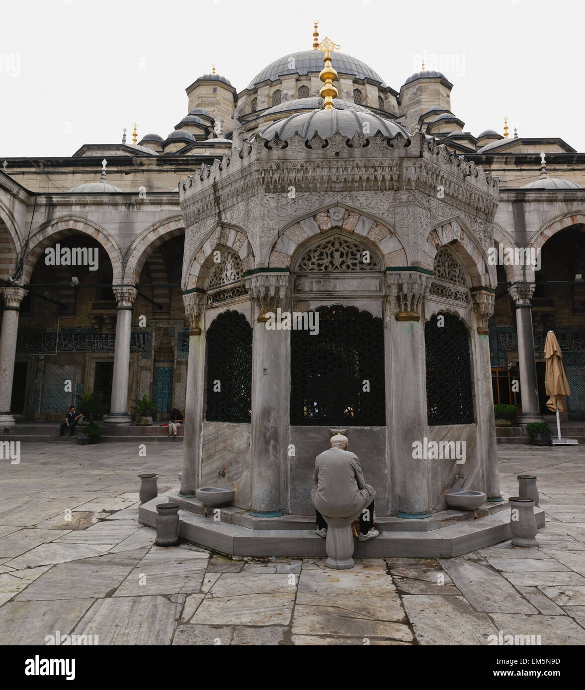 Turkey, Man sitting and washing his hands for ablution at Sultan Ahmed ...