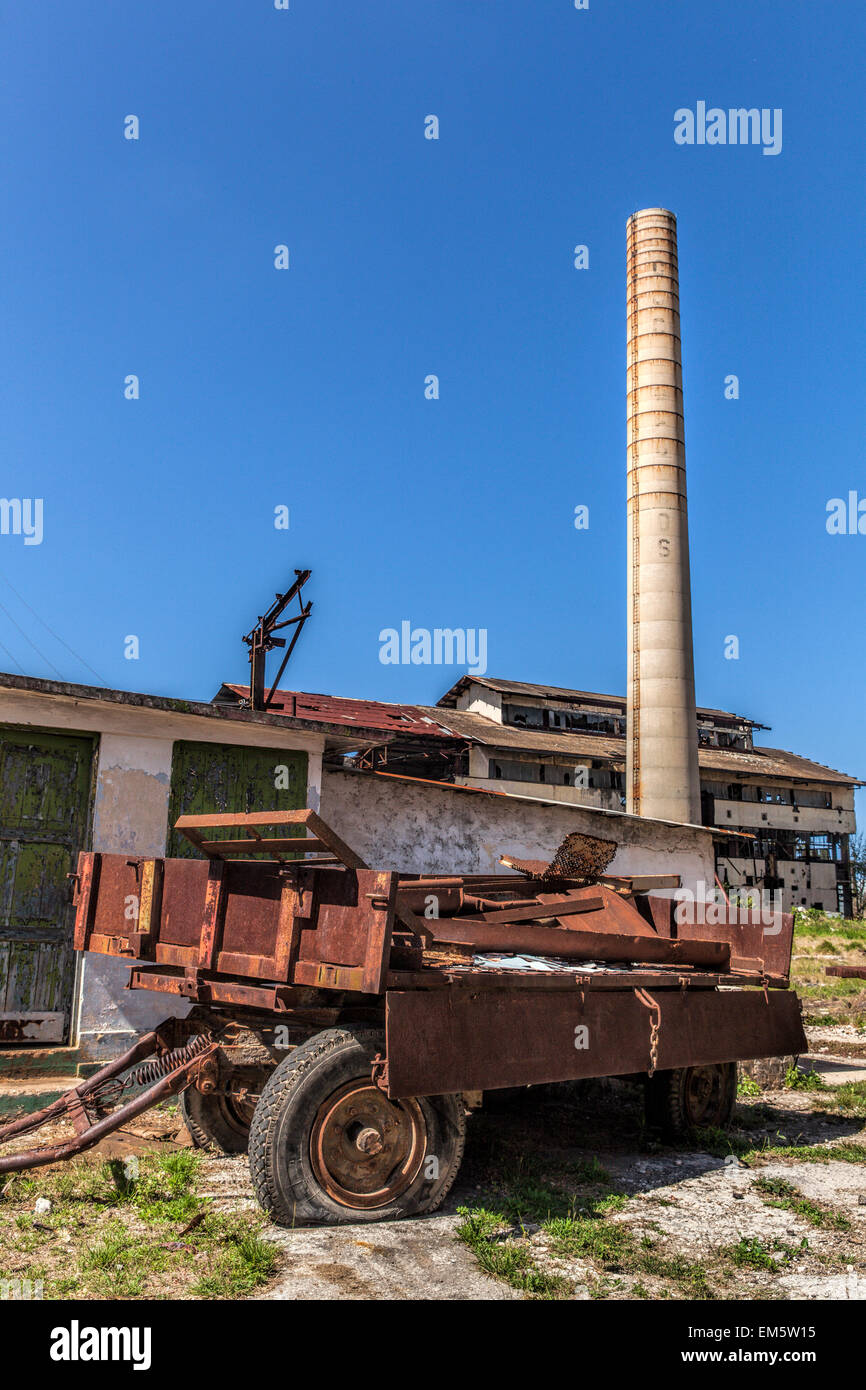 Old rusty broken down rail wagon outside a closed abandoned sugar mill ...
