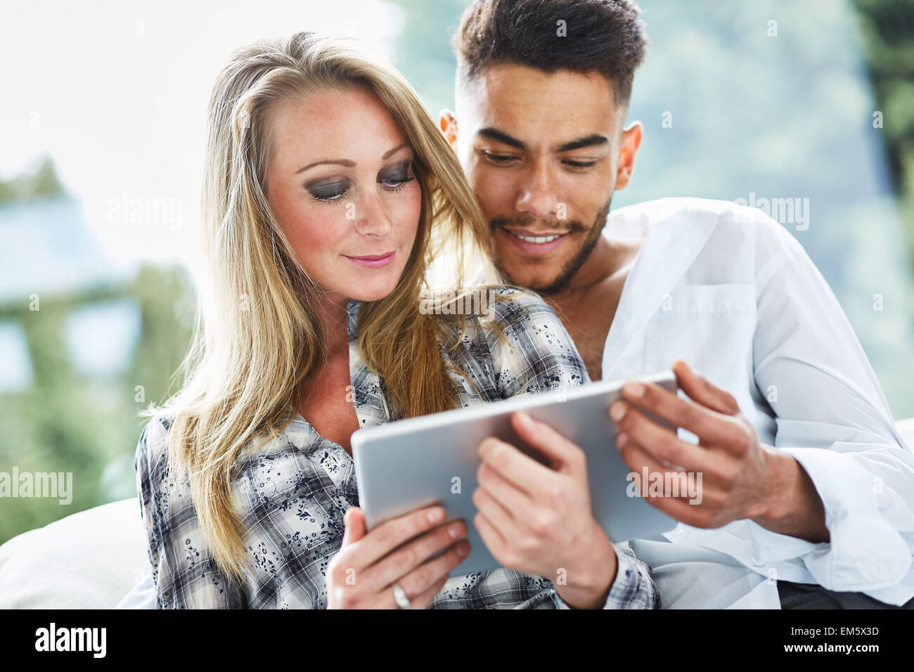Couple looking at an iPad together Stock Photo - Alamy
