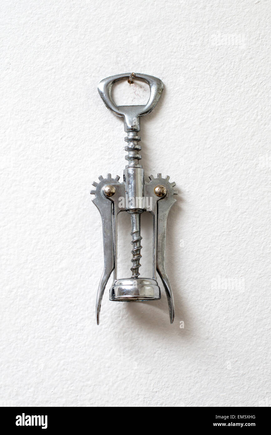 corkscrew hanging against white wall as a background Stock Photo - Alamy