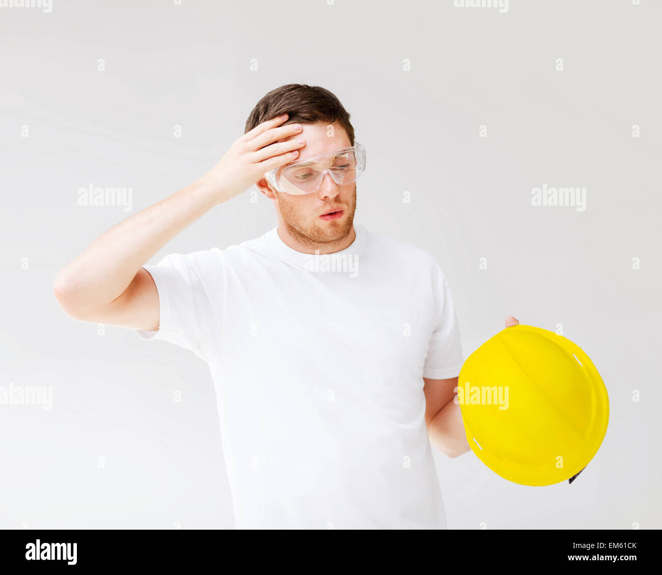 male builder in safety glasses taking off helmet Stock Photo - Alamy