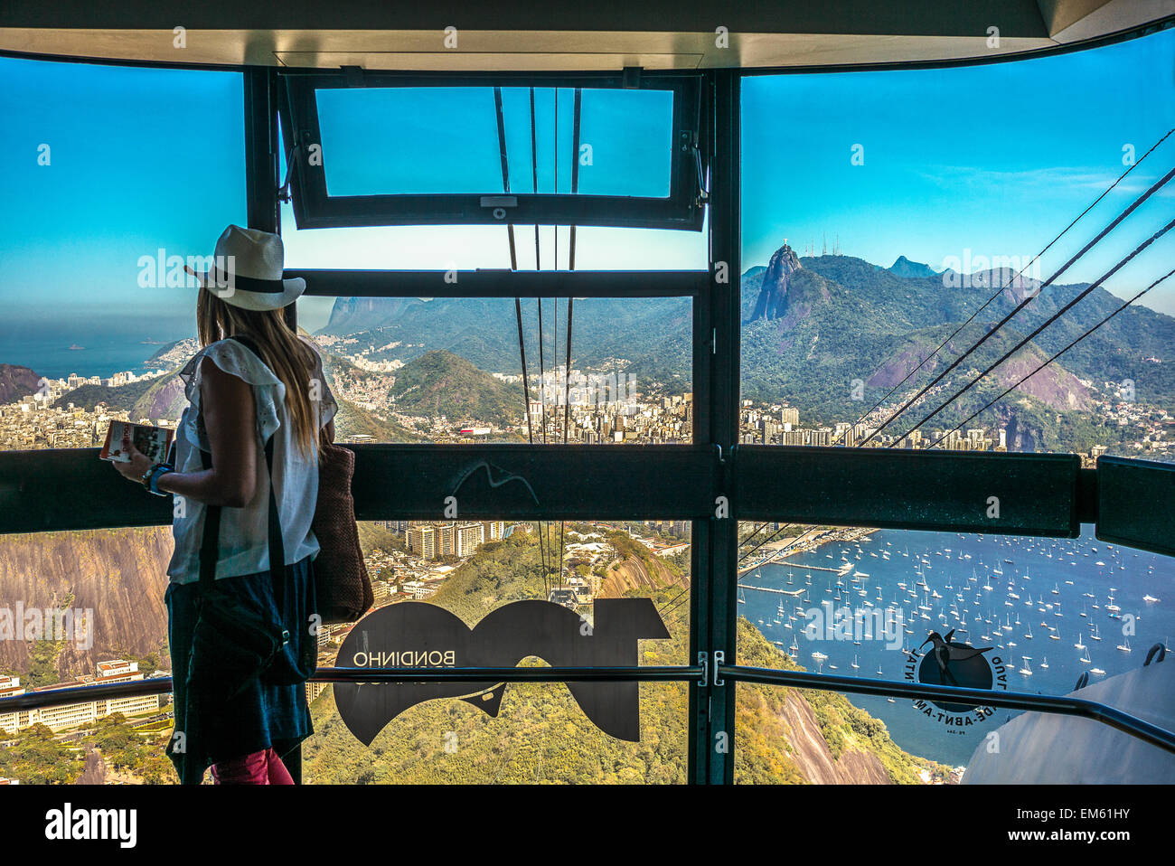 Brazil, Rio De Janeiro, a tourist on the cable car of the Pao De Acucar ...