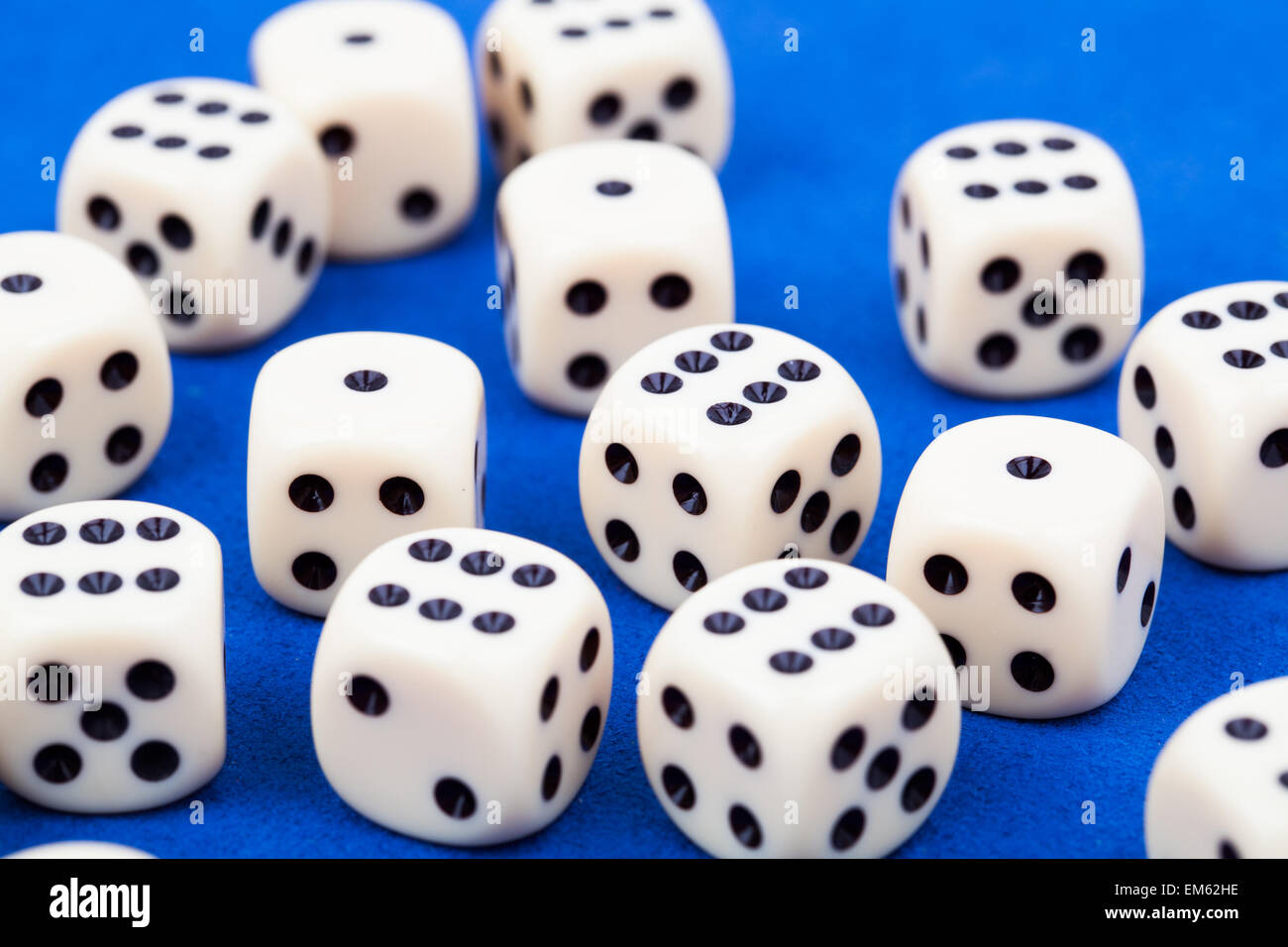 Dice rolling on blue background Stock Photo - Alamy