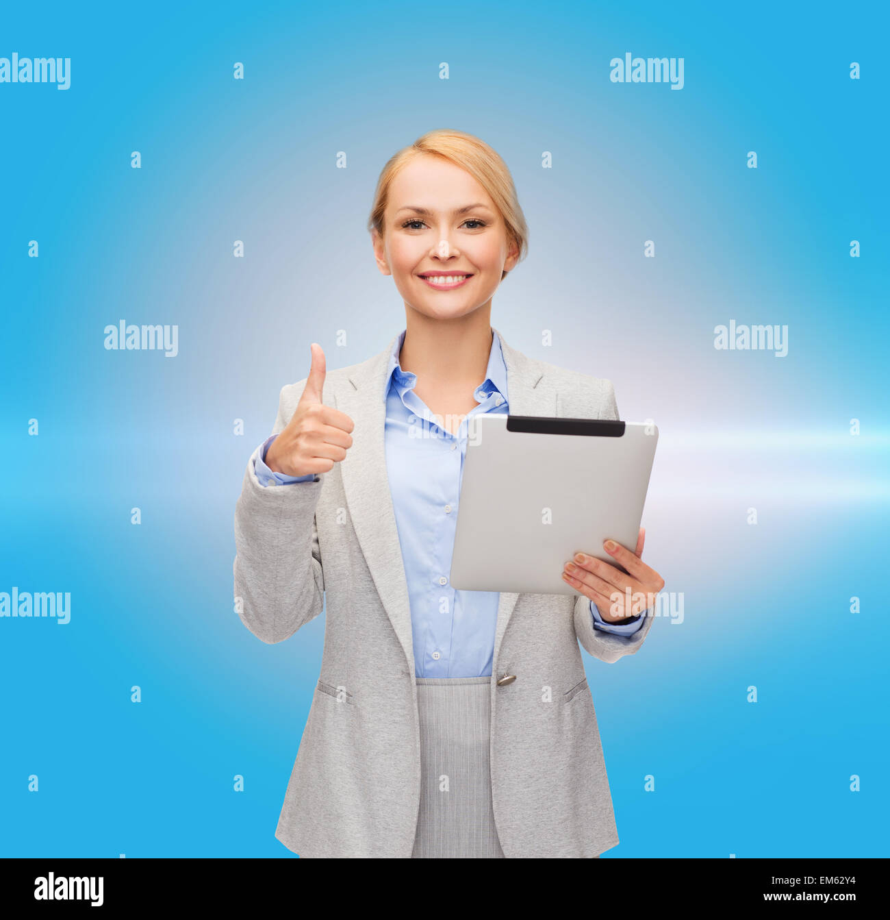 smiling woman with tablet pc showing thumbs up Stock Photo - Alamy