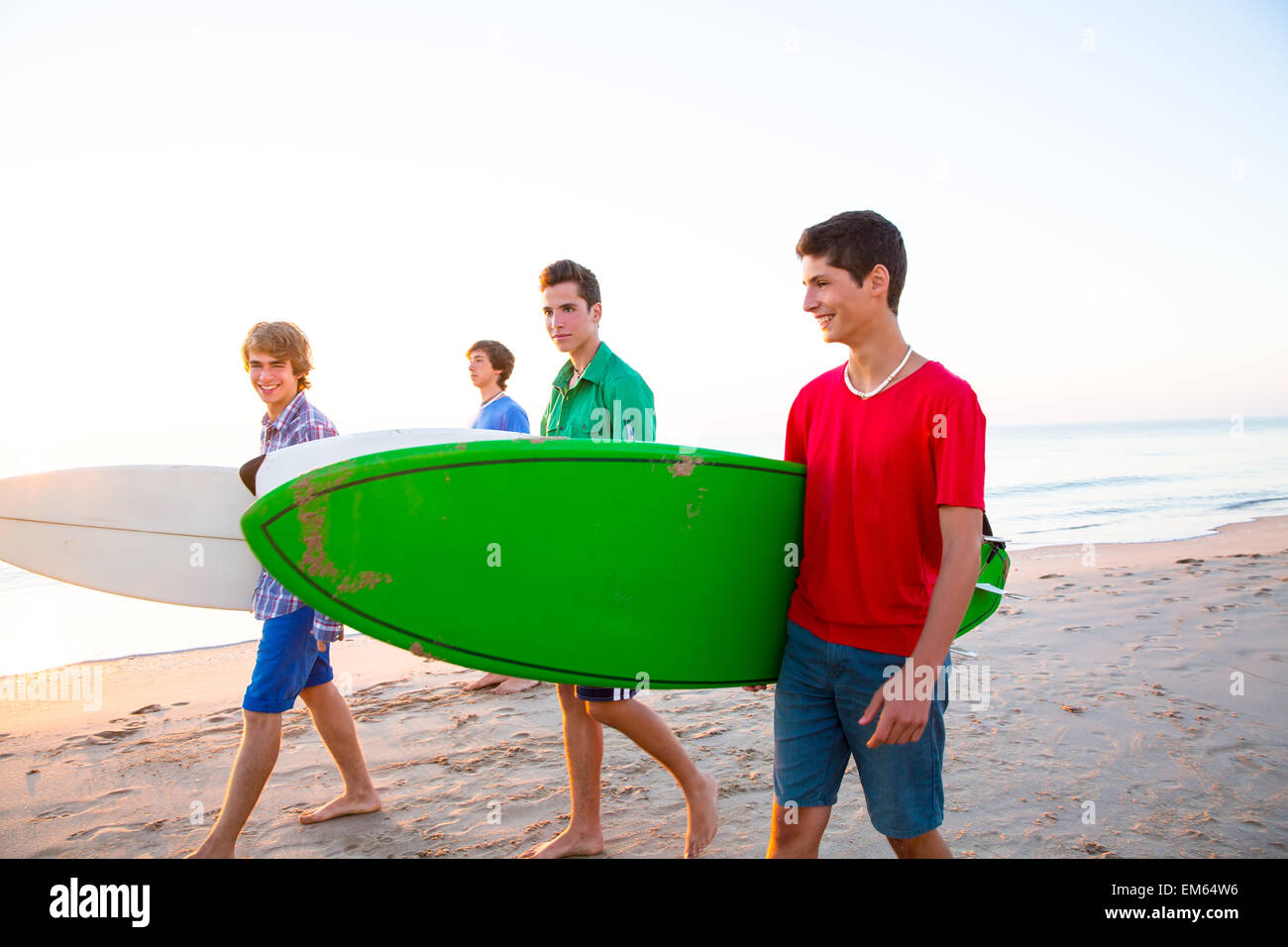 Surfer teen boys walking at beach shore Stock Photo - Alamy
