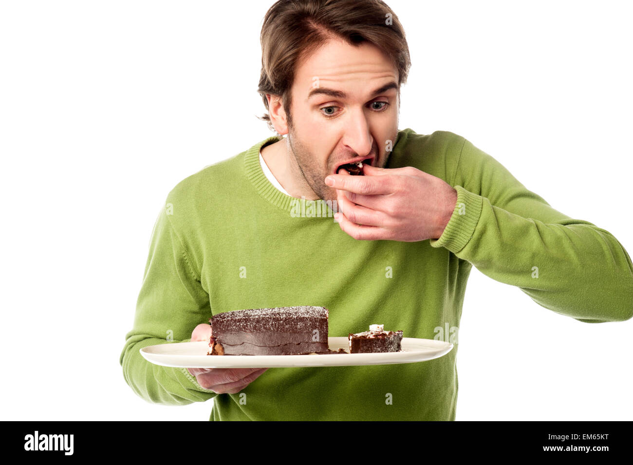 Young man tasting chocolate cake in hurry Stock Photo - Alamy