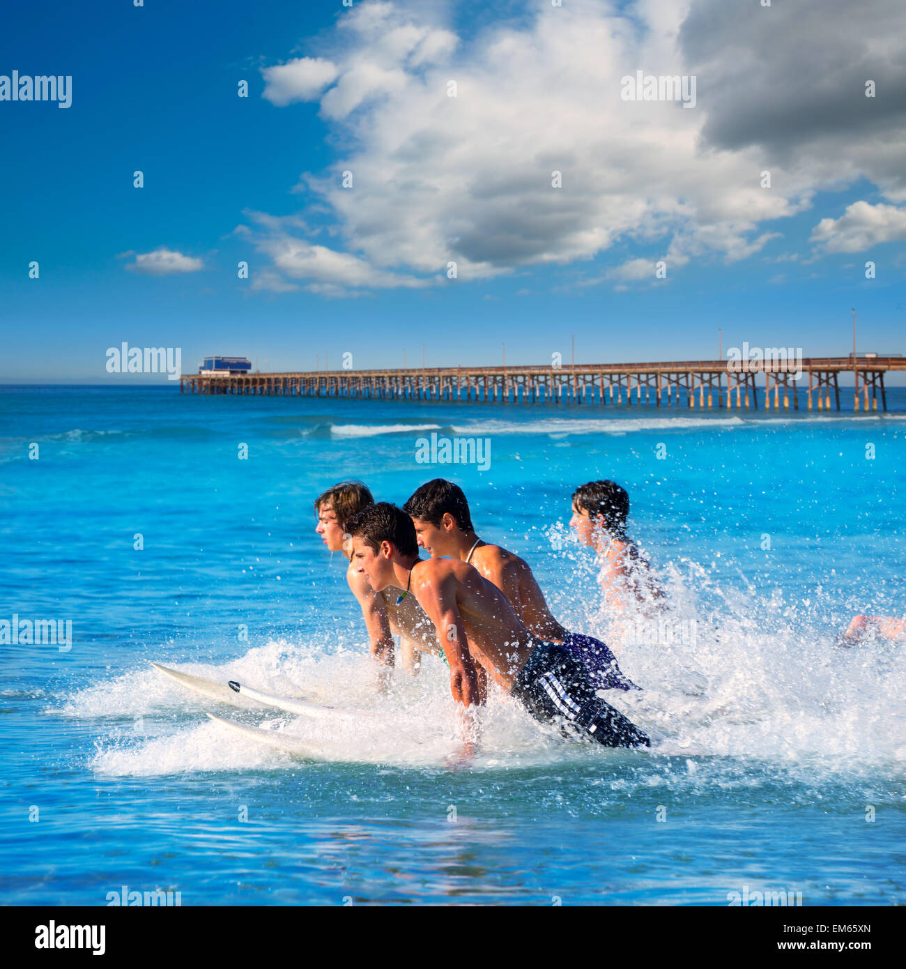 Teenager surfers running jumping on surfboards Stock Photo - Alamy