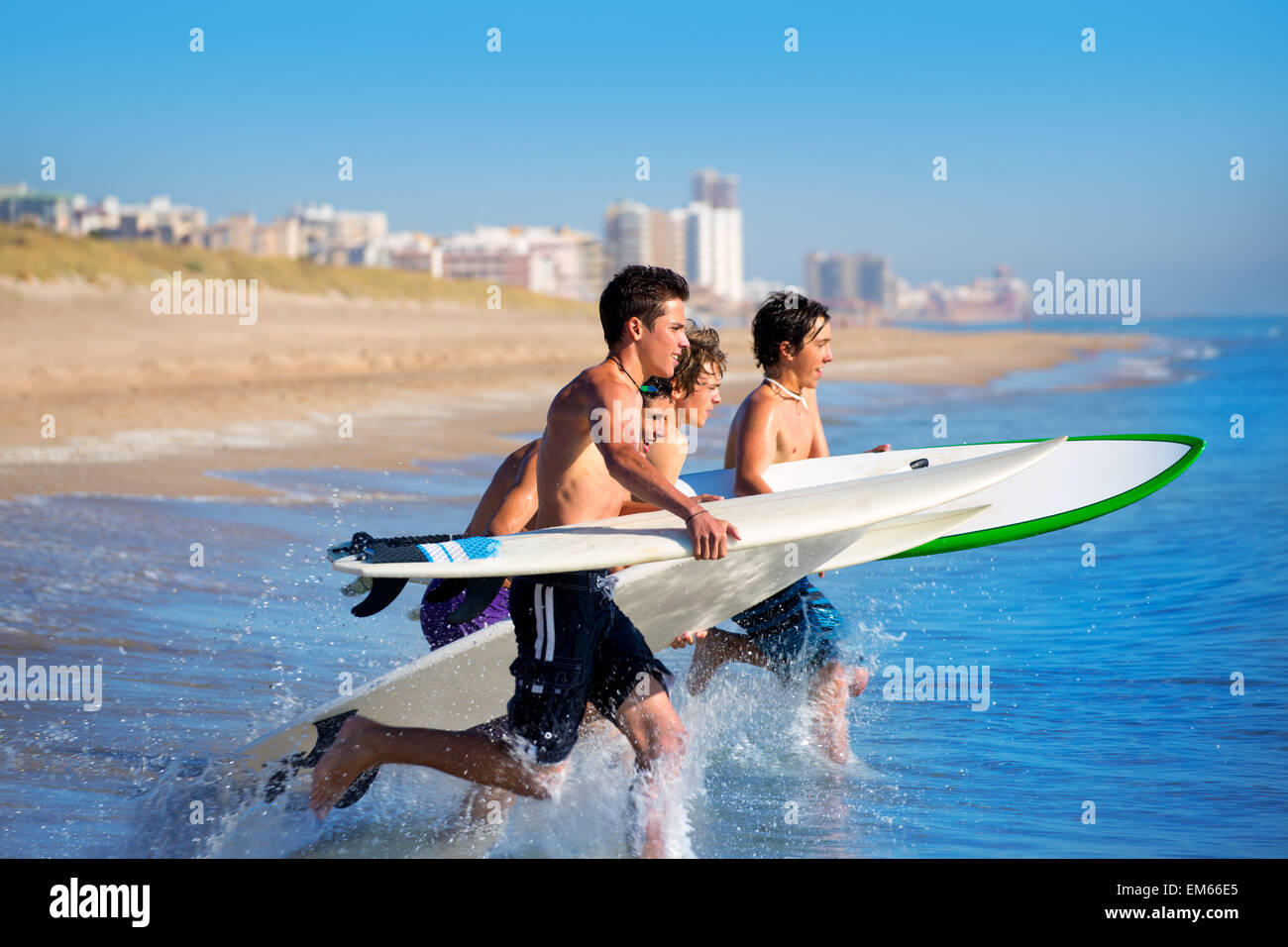 Boys surfers surfing running jumping on surfboards Stock Photo - Alamy