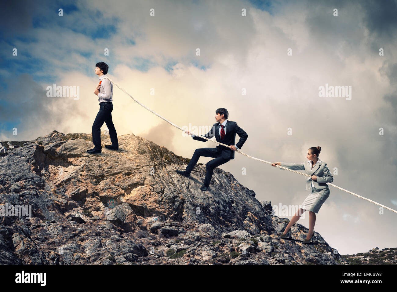 Three business people pulling rope Stock Photo - Alamy