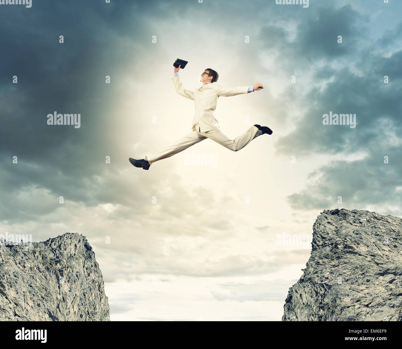 Businessman jumping over gap Stock Photo - Alamy