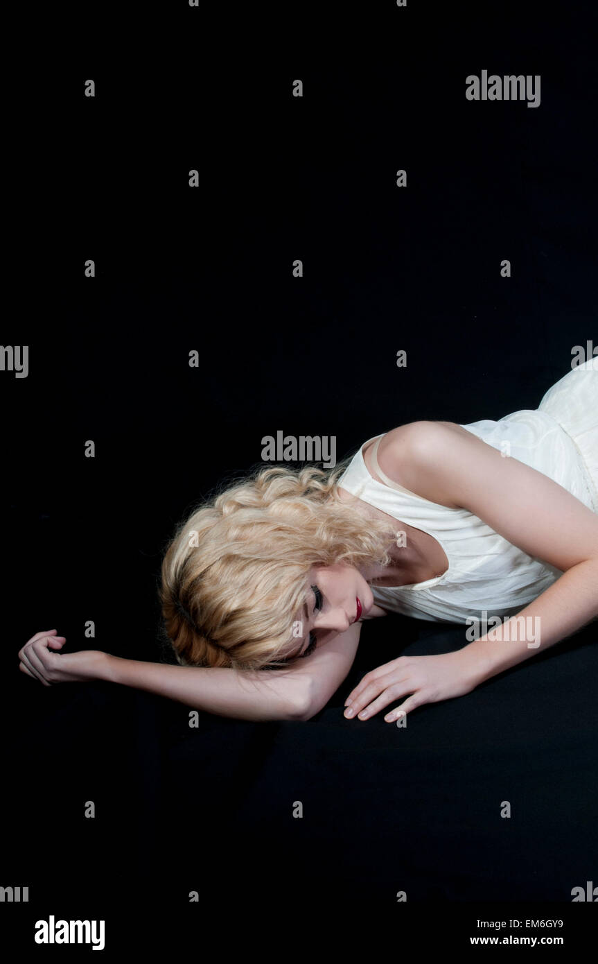 Sad young woman lying down Stock Photo - Alamy