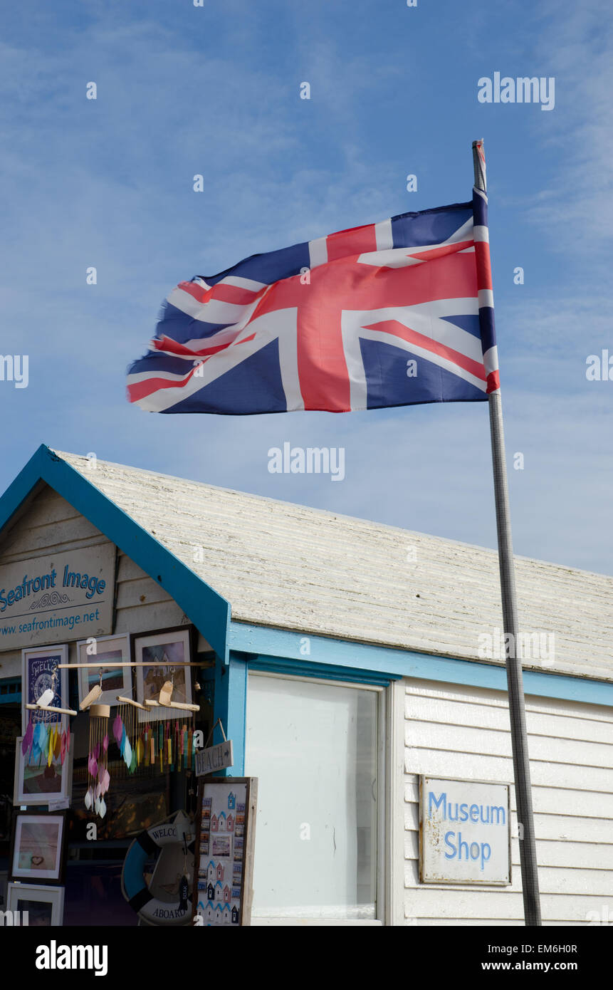 Union Jack flag blowing in the wind on a pole by a wooden shack in ...