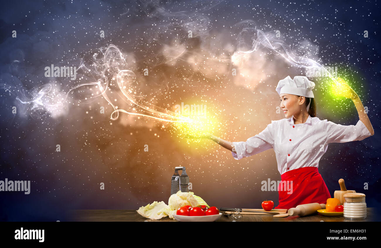 Asian female cooking with magic Stock Photo - Alamy