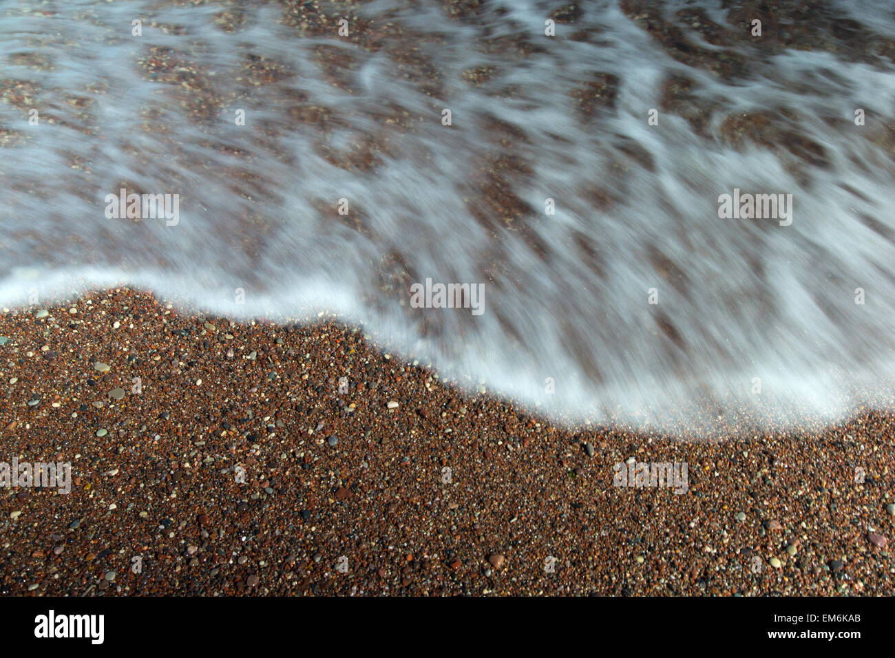 Waives over pebbles Stock Photo - Alamy