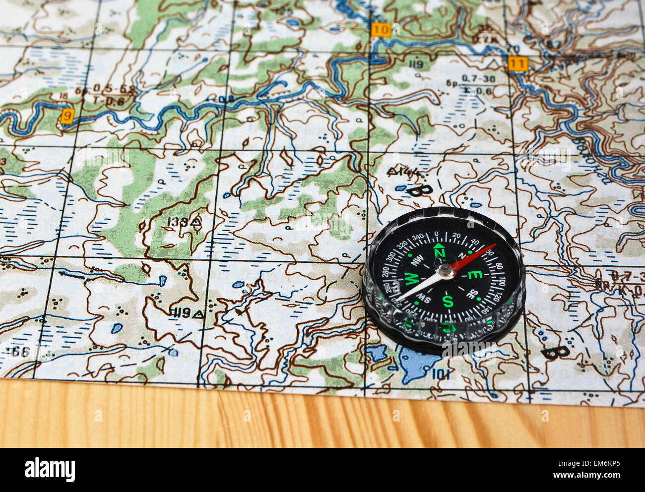 Geographical map and a compass. Photo magnetic compass located on a ...