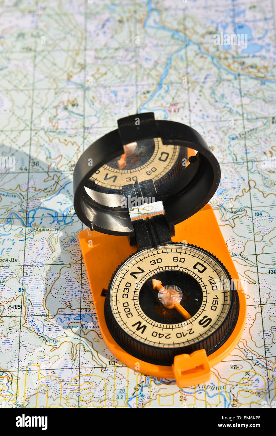 The compass on the map. Photo magnetic compass located on a topographic ...