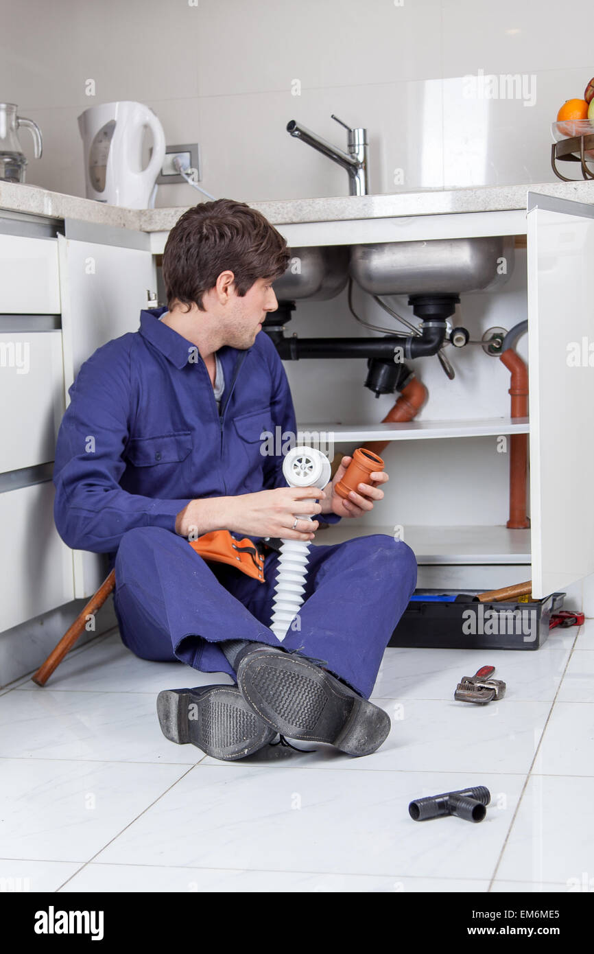 plumber fixing the kitchen Stock Photo - Alamy
