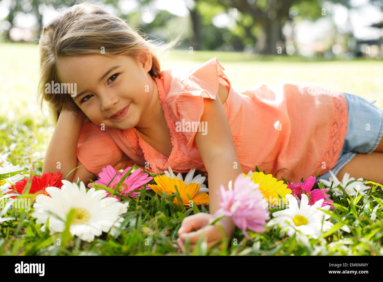 Young Girl Playing With Flowers In The Grass Stock Photo - Alamy