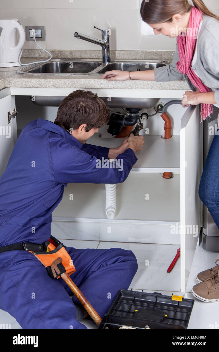 woman and plumber in the kitchen Stock Photo - Alamy