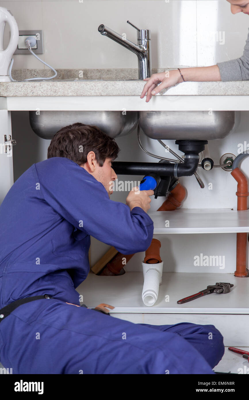 plumber fixing the kitchen Stock Photo - Alamy