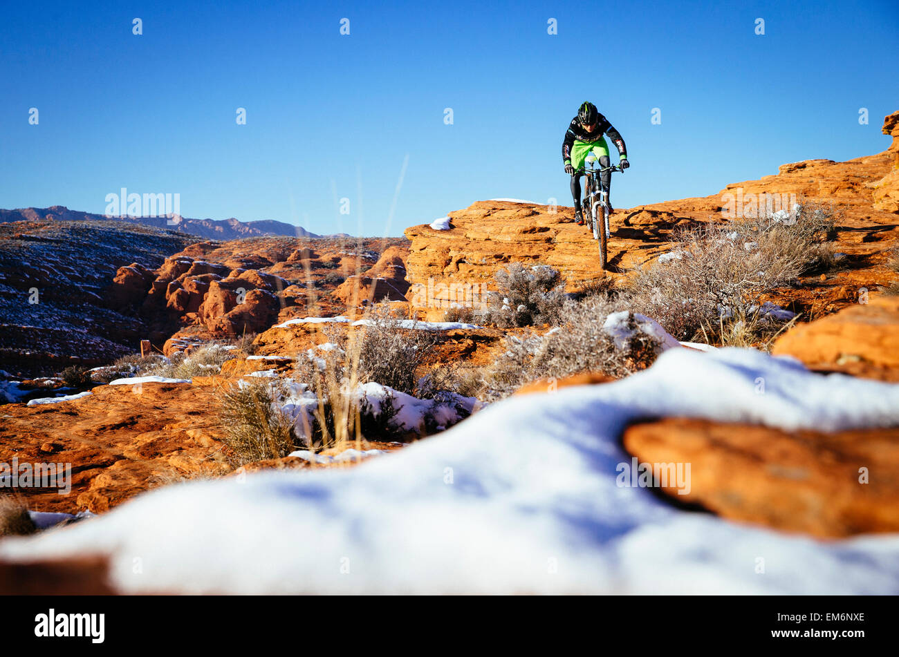 A man riding his mountain bike in the snow outside of St. George, Utah ...